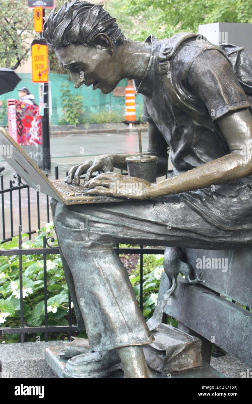 Statue of a student hurrying to finish his paper on his computer ...