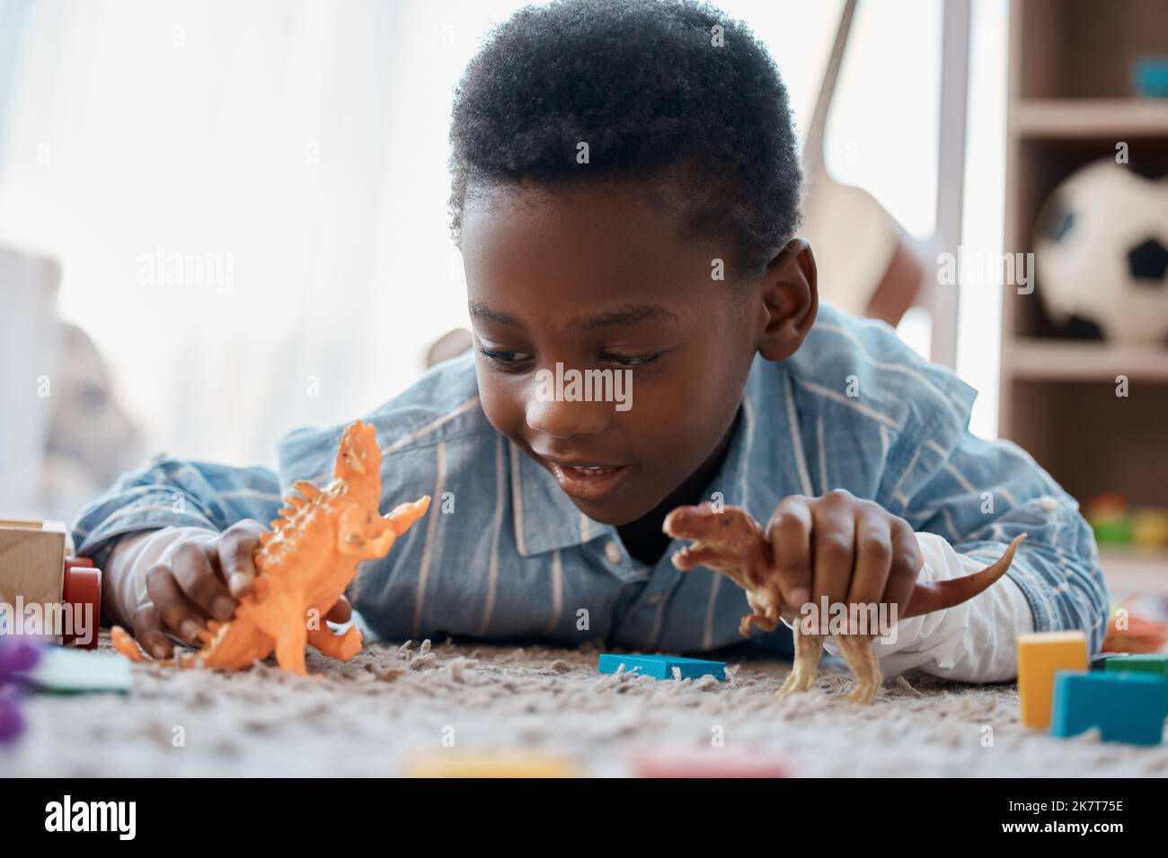 Dinosaurs is his favourite animal. an adorable little boy playing with ...