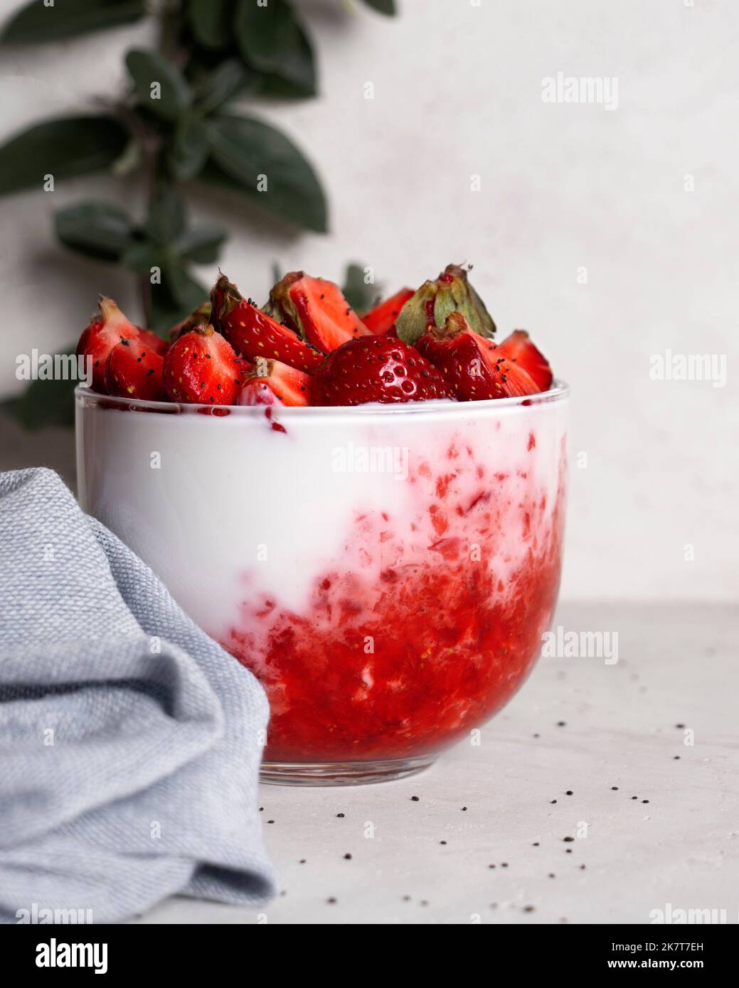 A cup of yogurt mixed with berry puree and granola with strawberry ...