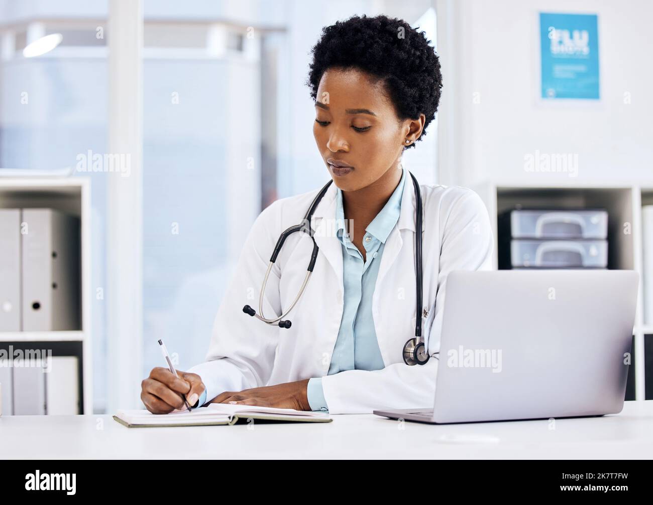 Taking notes to better her ability. an attractive young female doctor ...