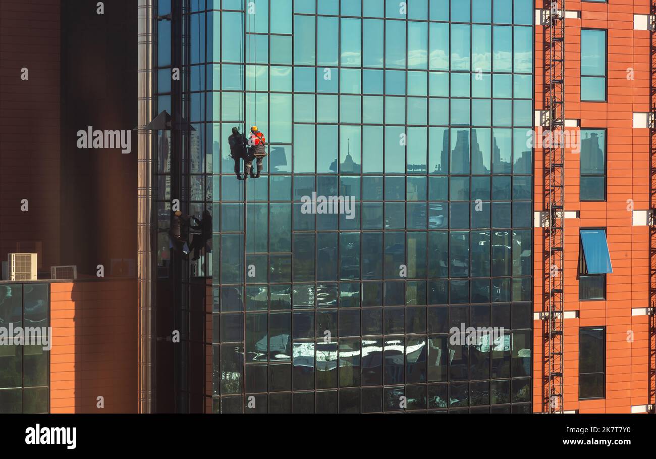 High-rise workers wash the facade and glass of a skyscraper Stock Photo ...