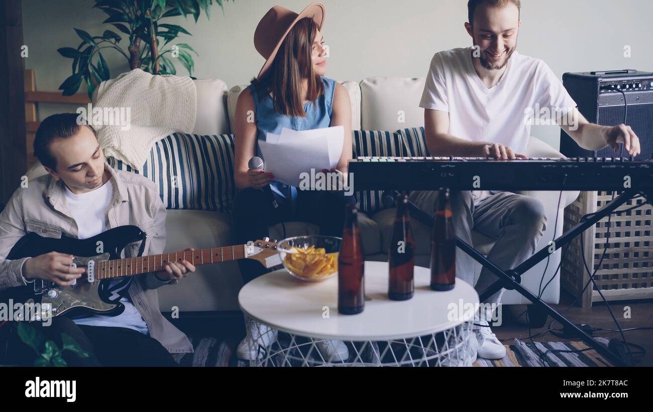 Popular musical band is practising at home, guitarist is sitting on ...