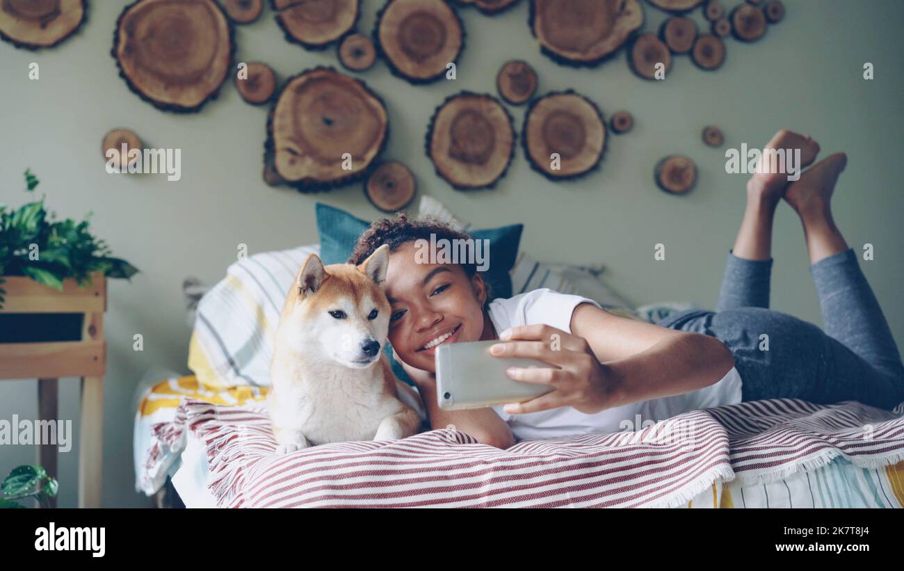 Cheerful girl is taking selfie with cute pet posing with beautiful dog ...