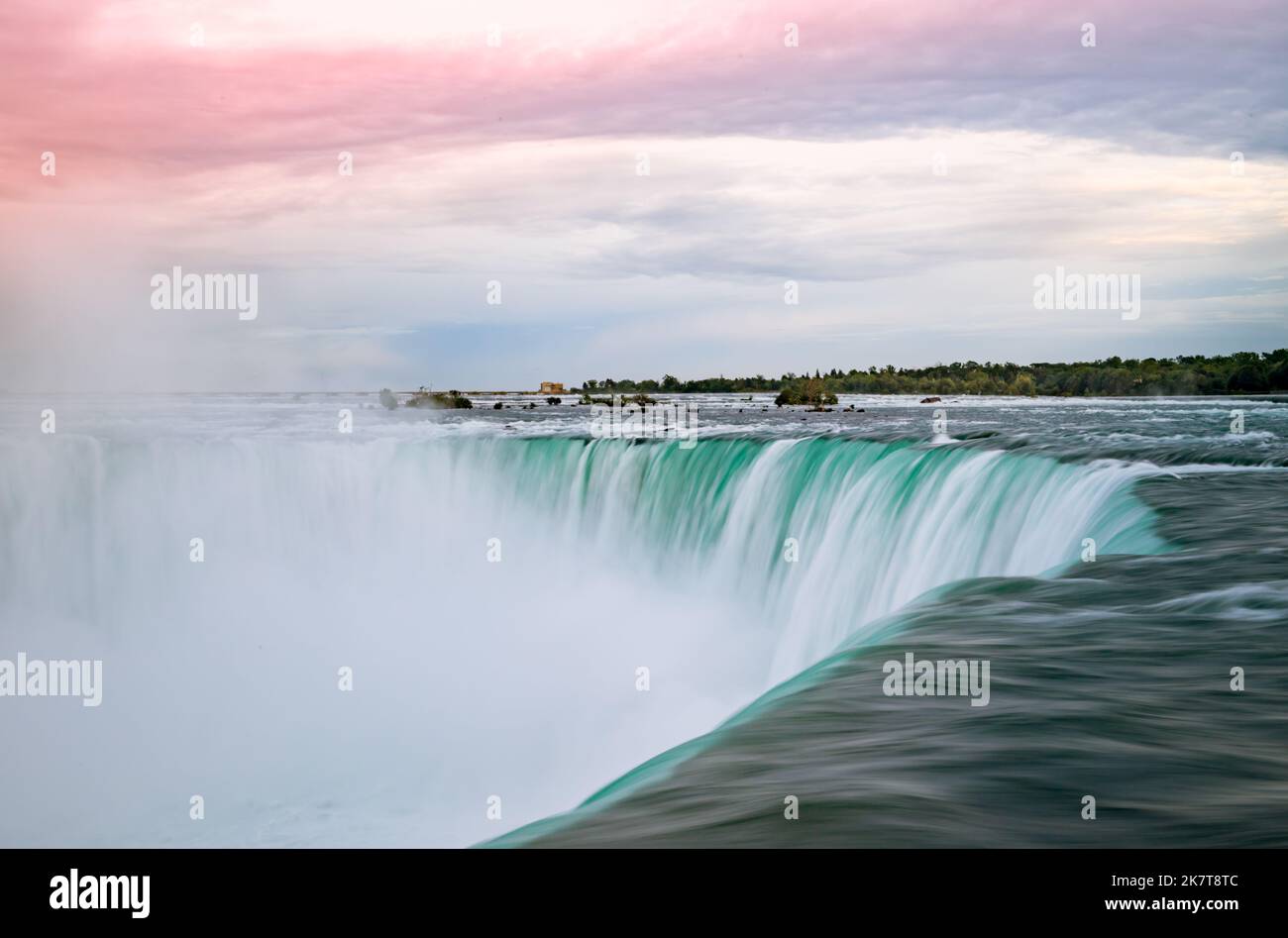 Niagara Horseshoe falls on sunset - blue water, haze and cloudy sky ...
