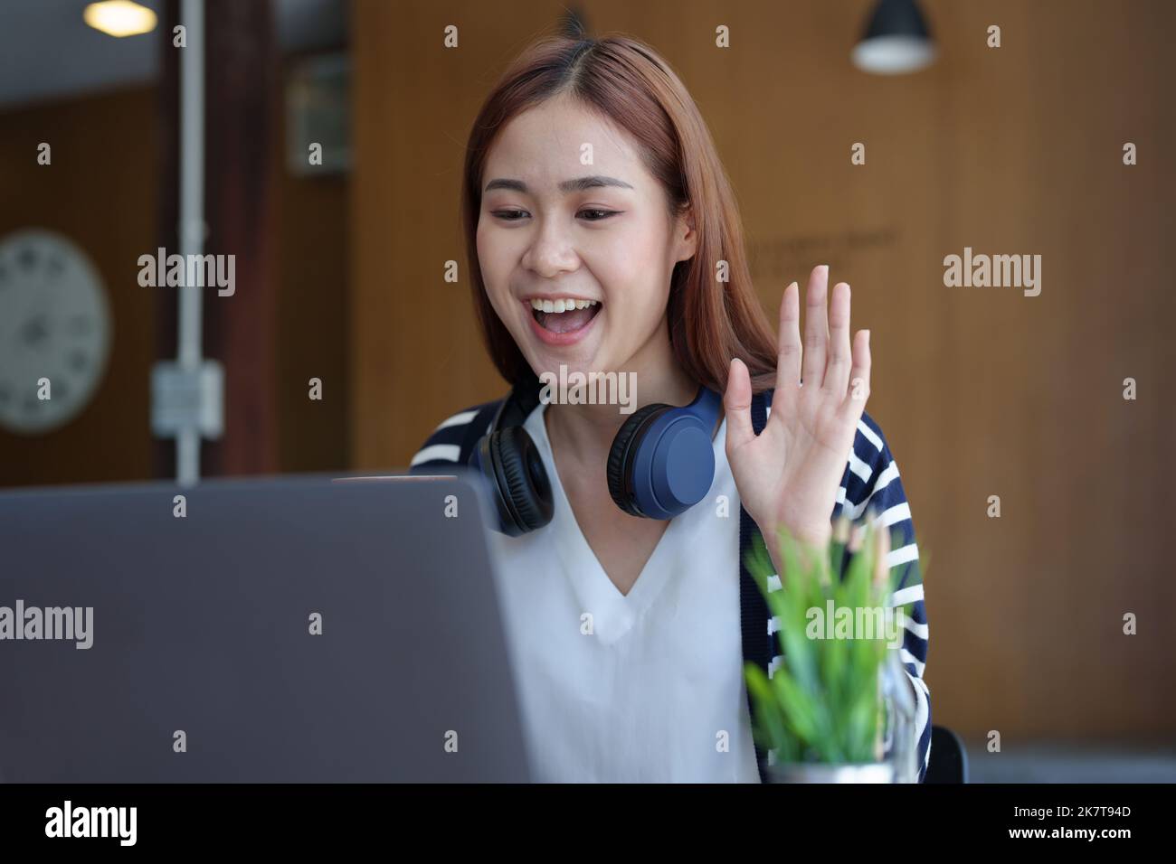Portrait of a young Asian teenage girl in love wearing headphones ...