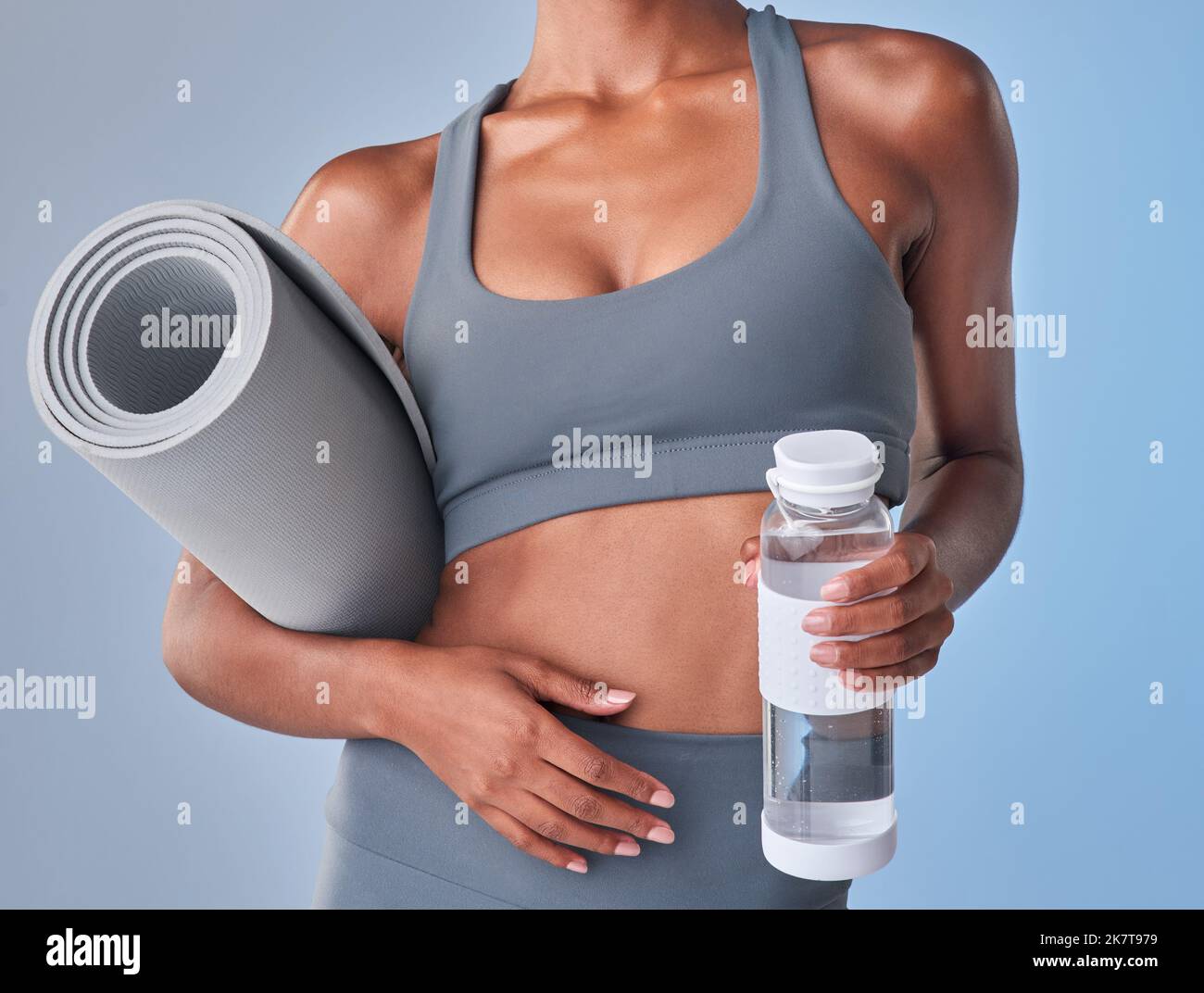 Ready to make a change. Studio shot of a fit woman drinking bottled water against a grey ...