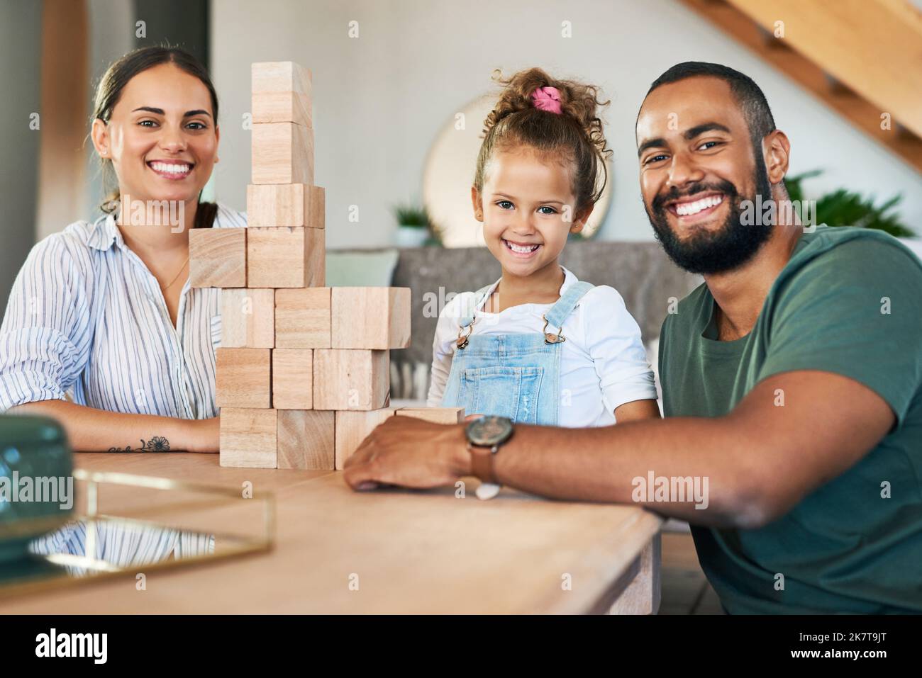 Playtime is fun for all. Portrait of a happy family playing with wooden ...