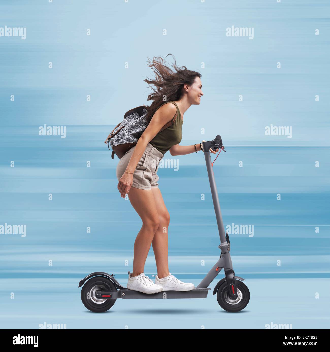 Happy young student riding a fast eco-friendly electric scooter, smart ...