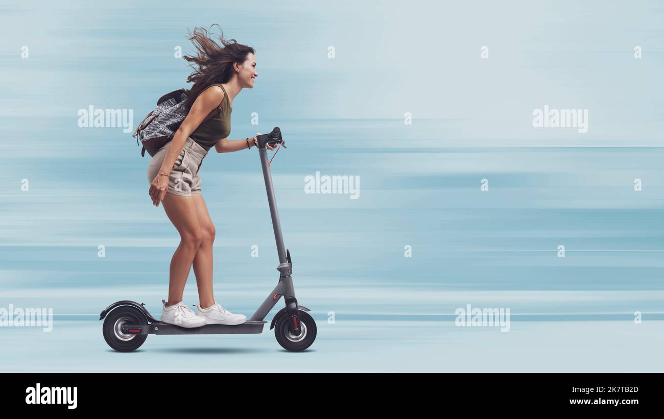 Happy young student riding a fast eco-friendly electric scooter, smart ...