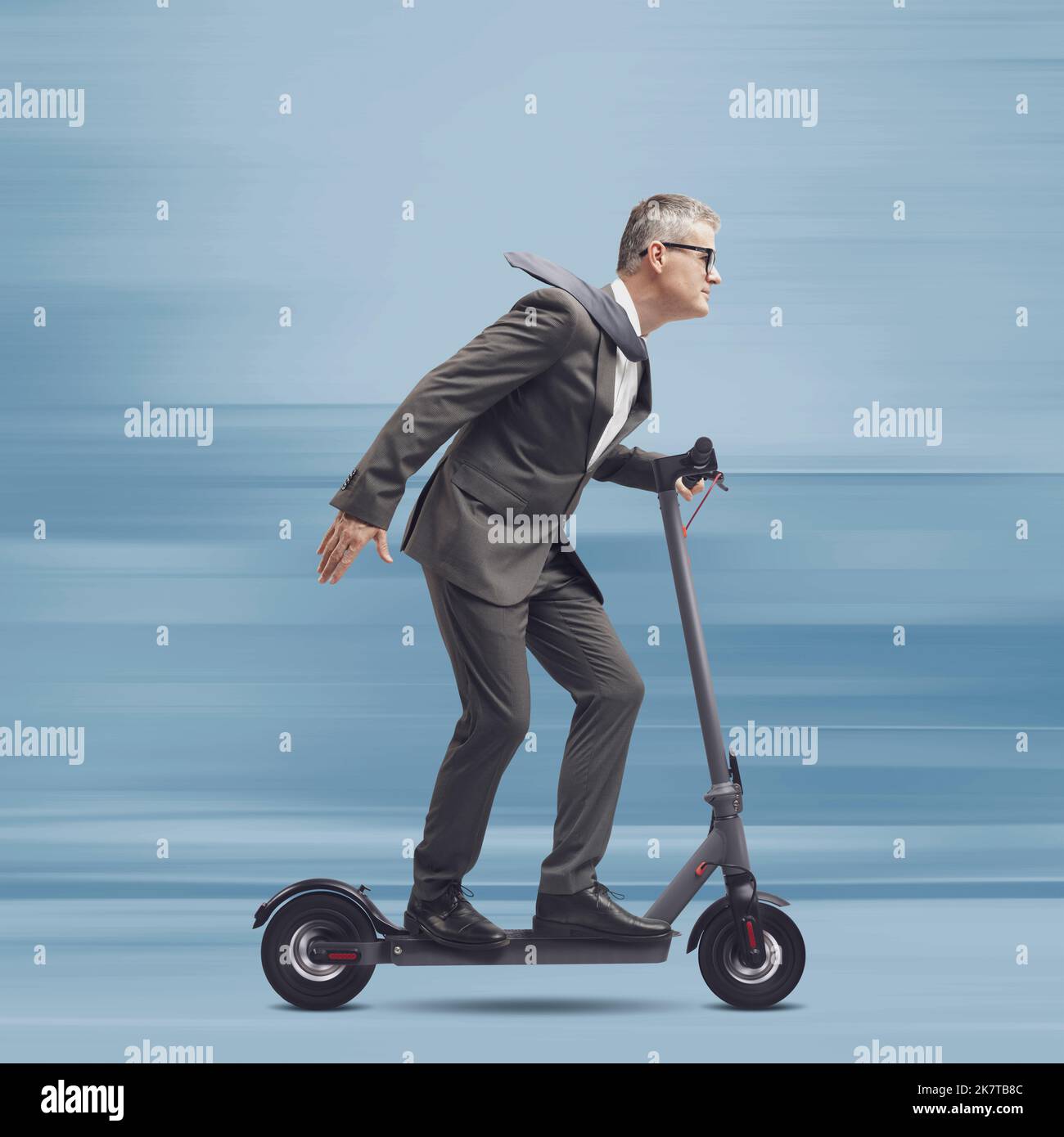 Corporate businessman riding a fast eco-friendly electric scooter ...