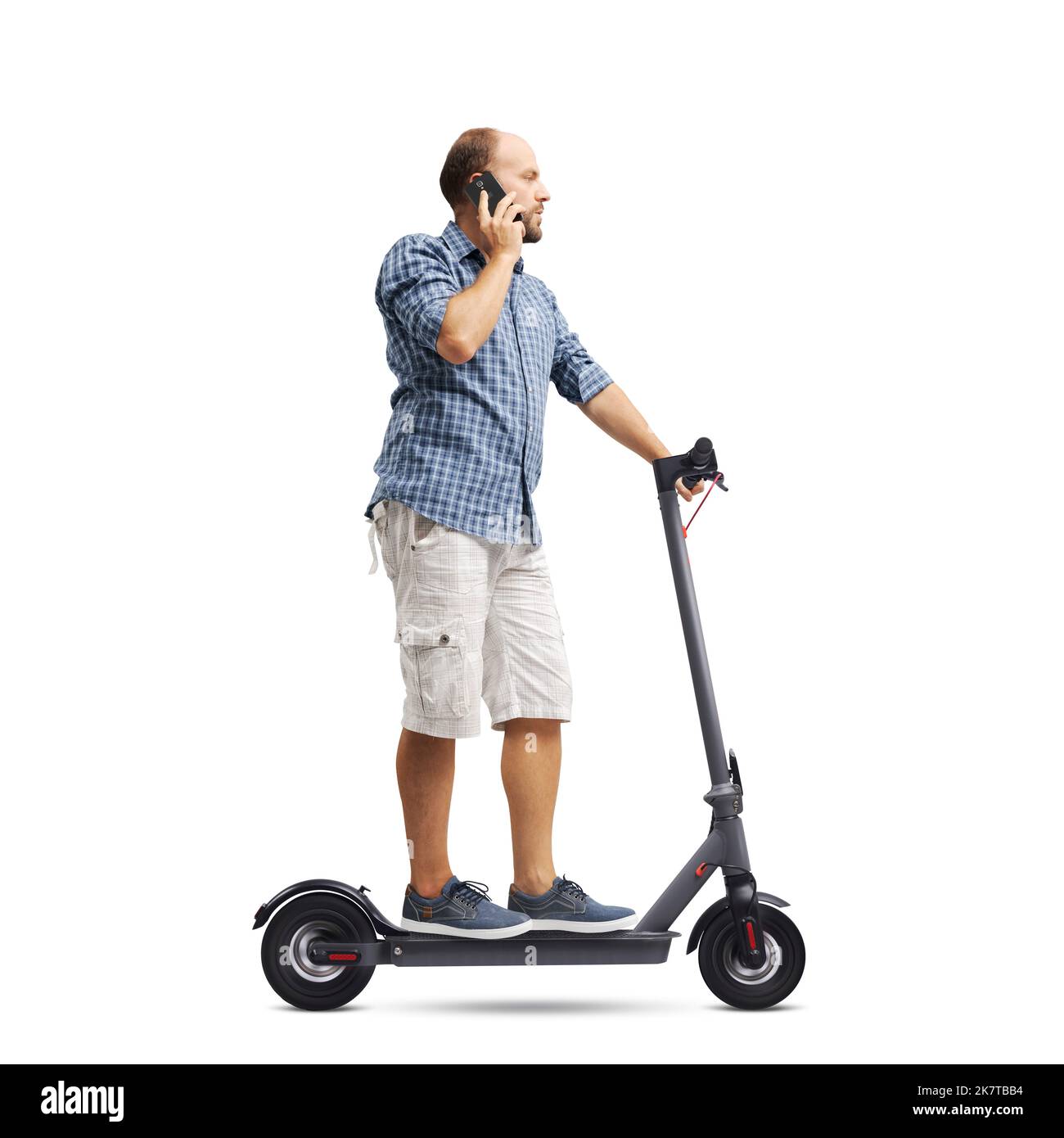 Man having a phone call with his smartphone and riding an electric ...