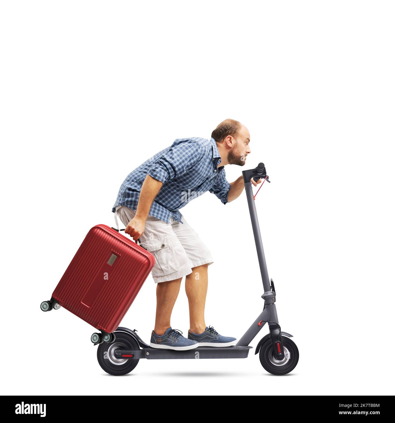 Traveller man holding a trolley bag and riding a fast electric scooter ...