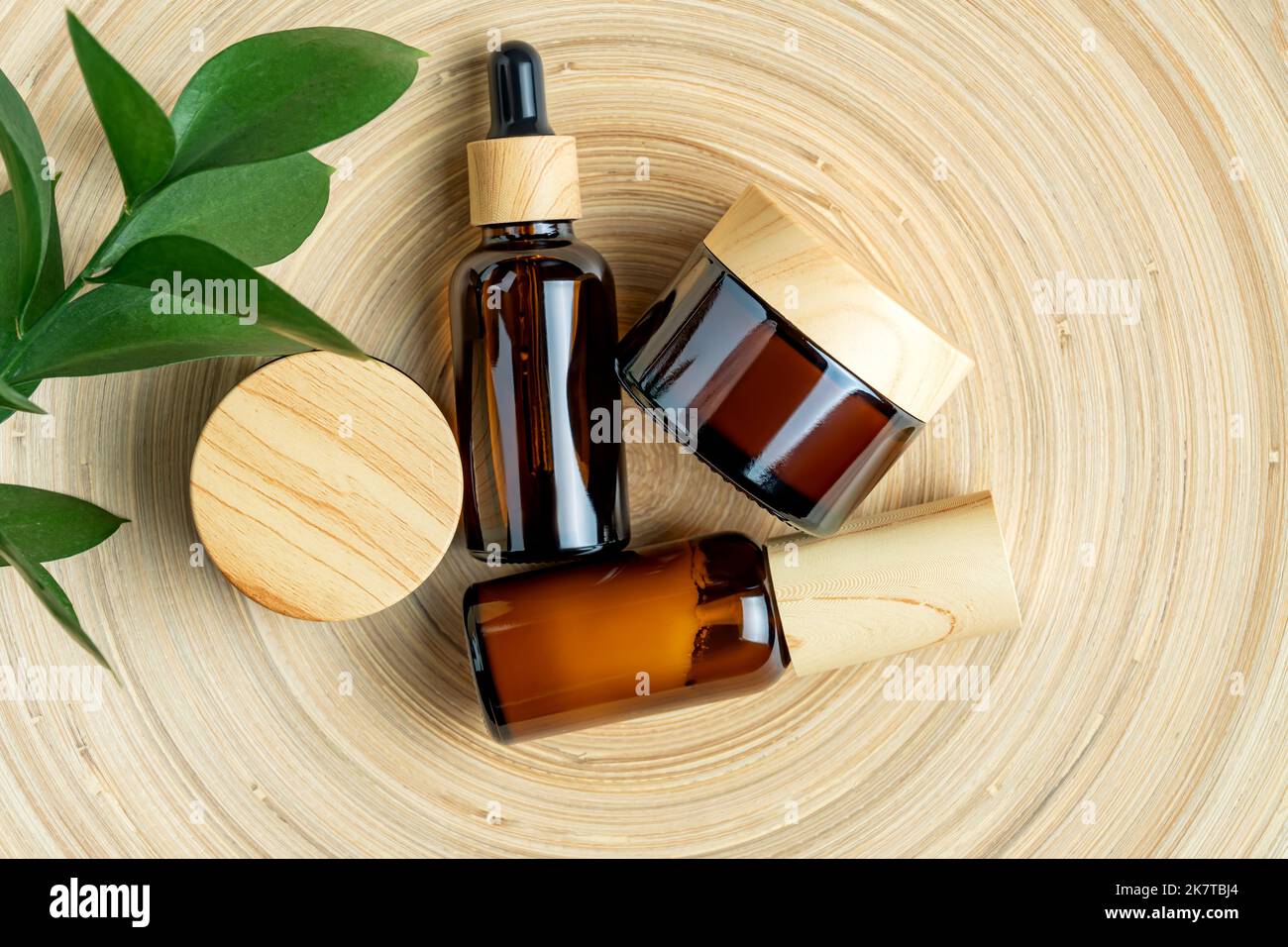 Set of amber glass cosmetic bottles on bamboo tray. dropper bottle and ...