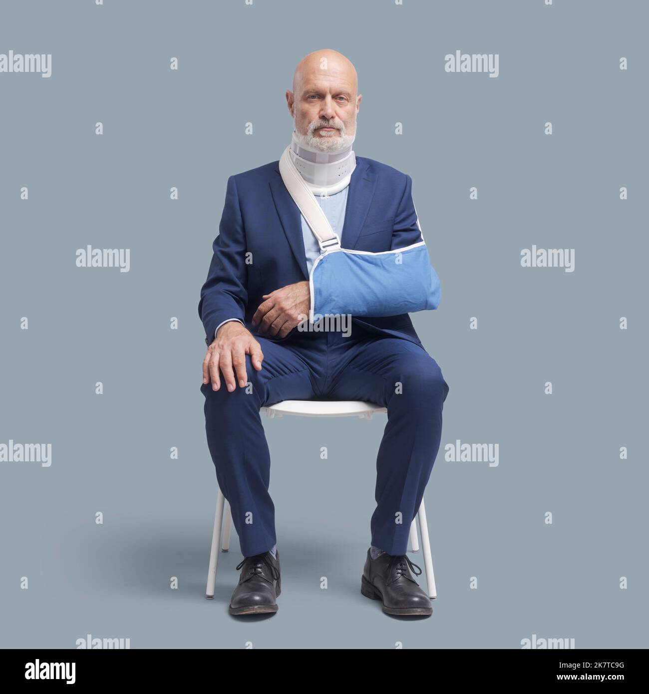 Injured patient wearing a neck brace and broken arm sling, healthcare ...