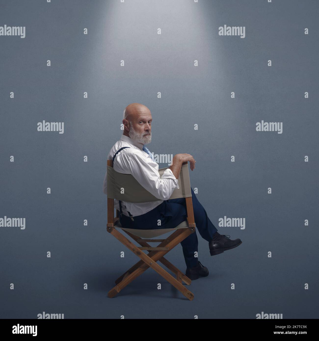 Confident film director sitting on the director's chair and looking at ...