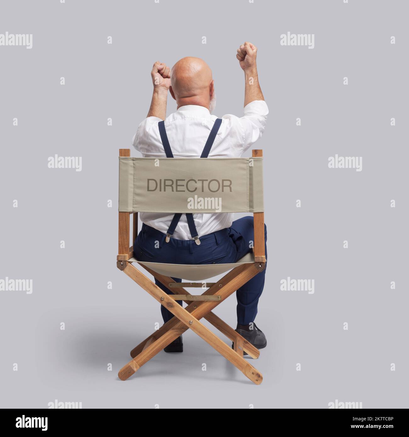 Angry disappointed film director sitting on the director's chair and ...