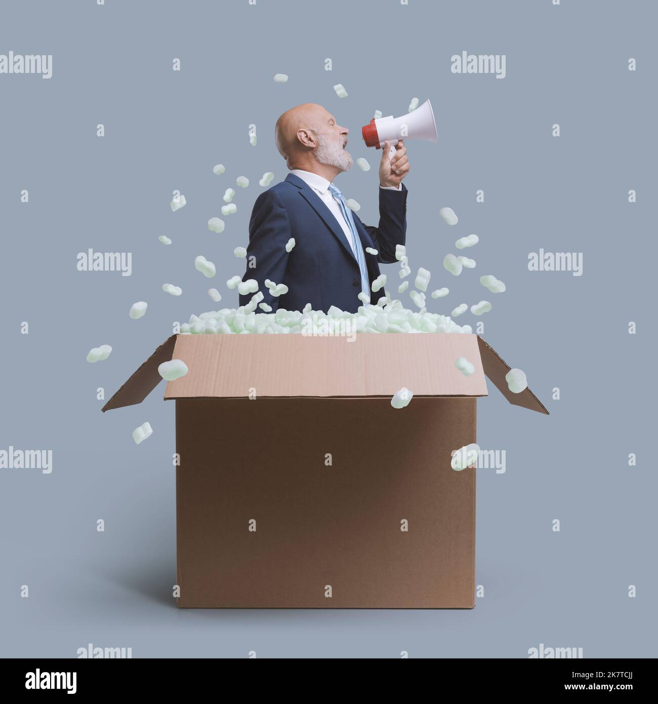 Businessman shouting with a megaphone in a delivery box, business and ...