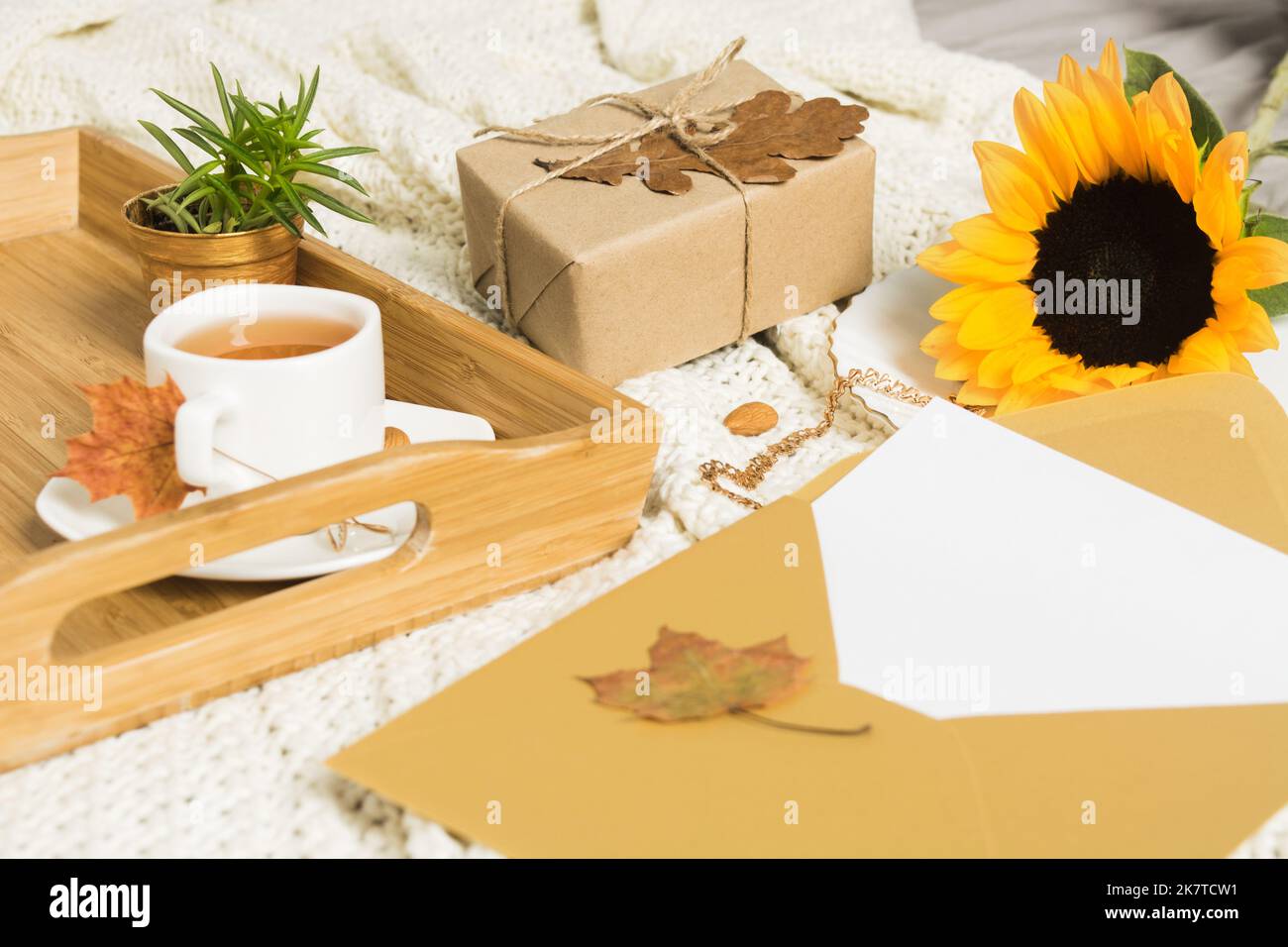 Autumn mockup with letter in golden envelope, tea, sunflowers and gift ...