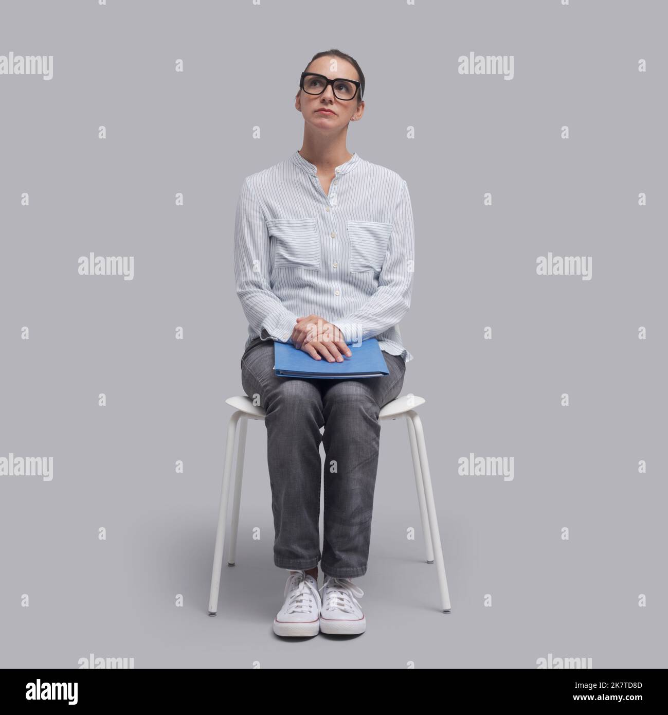 Pensive woman sitting on a chair and waiting for a job interview Stock ...