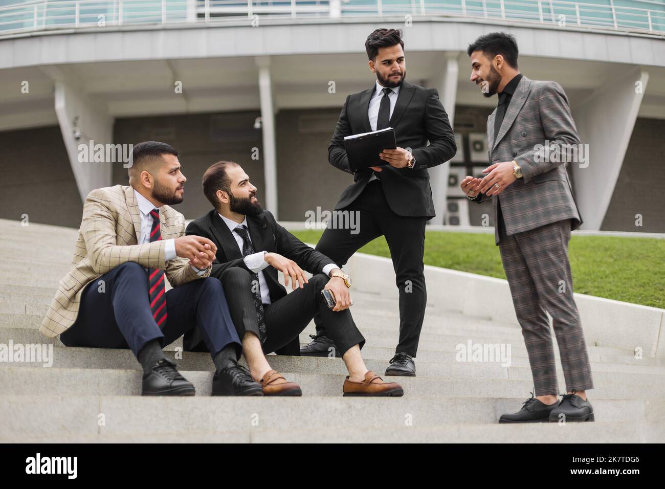 Business people outdoor meeting. A company of male businessmen in suits ...