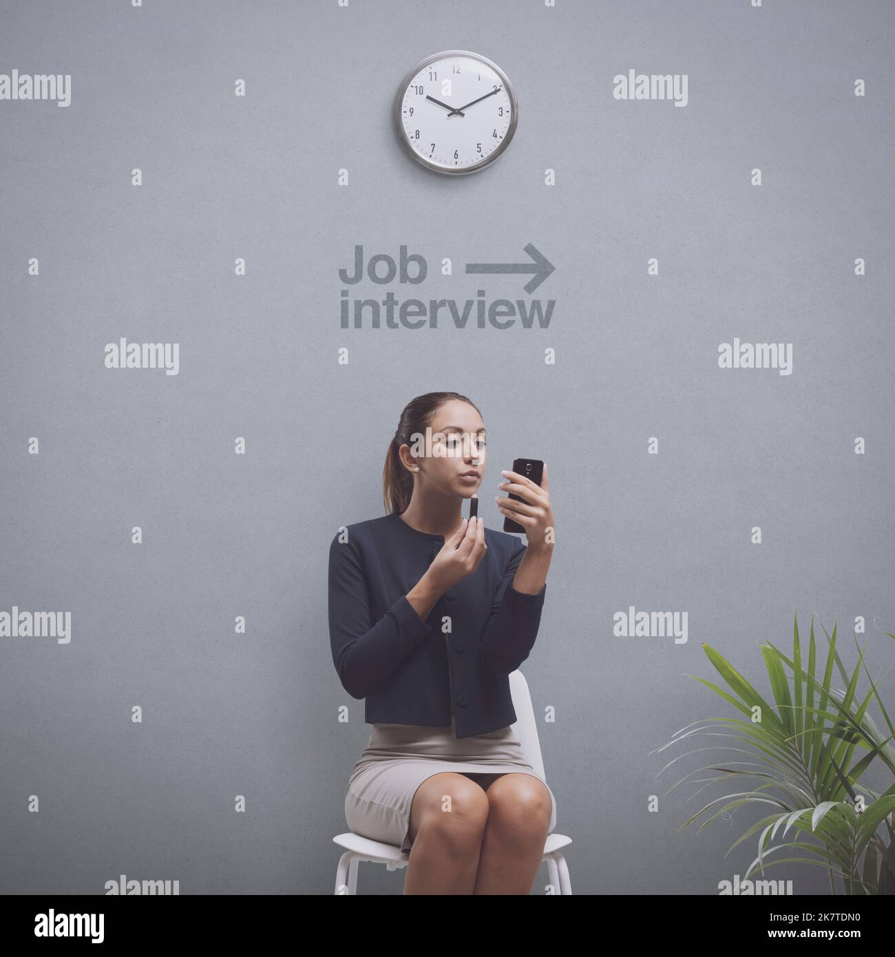 Attractive woman touching up her makeup before having a job interview ...