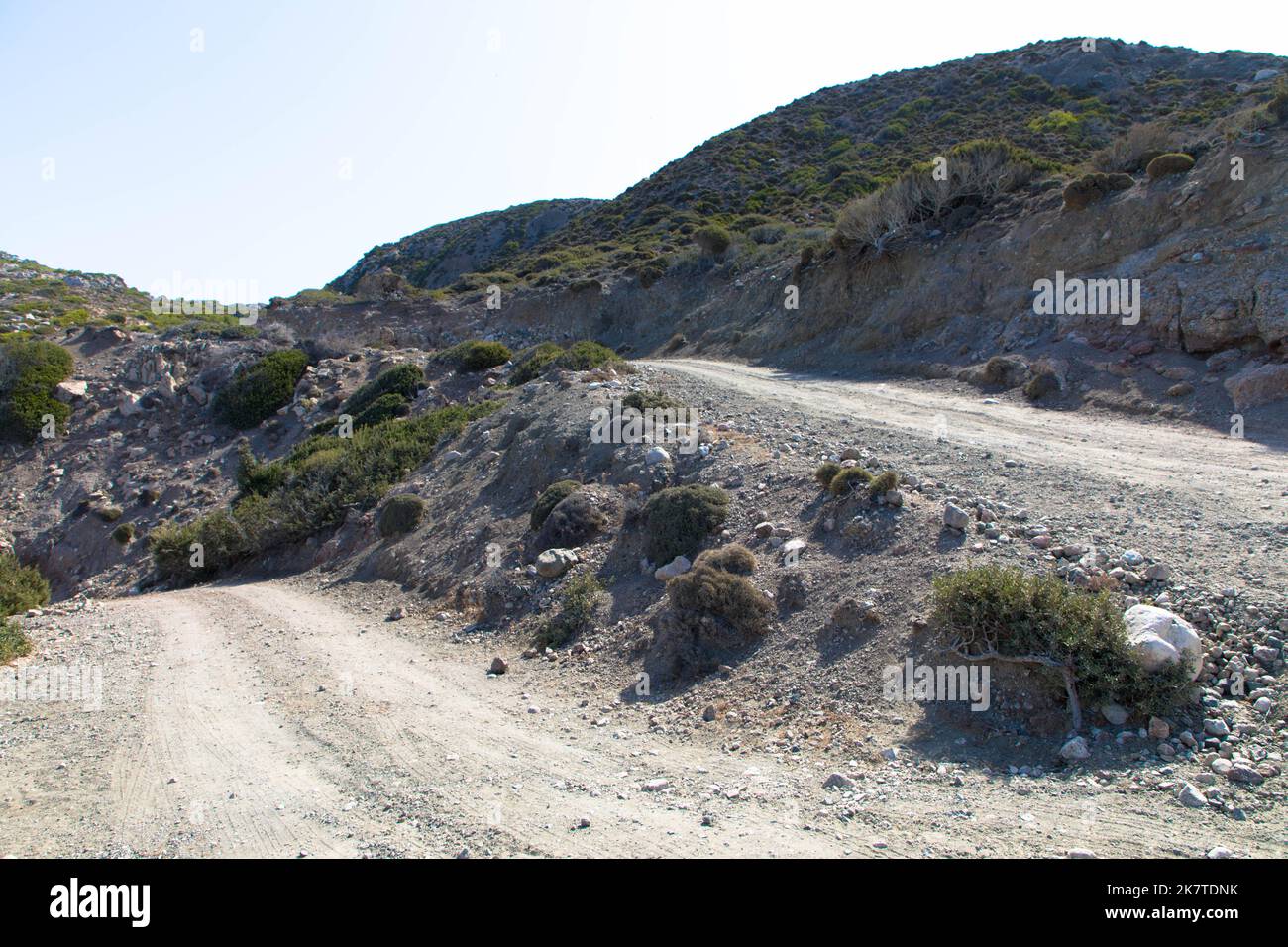 Gravel road to the top of Attavyros mountain. Arid landscape and blue ...