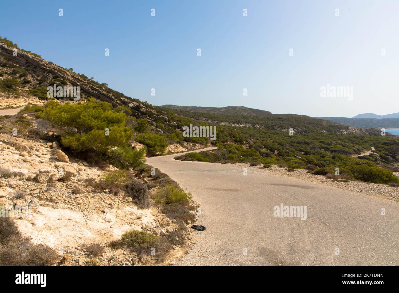 Gravel road to the top of Attavyros mountain. Arid landscape and blue ...