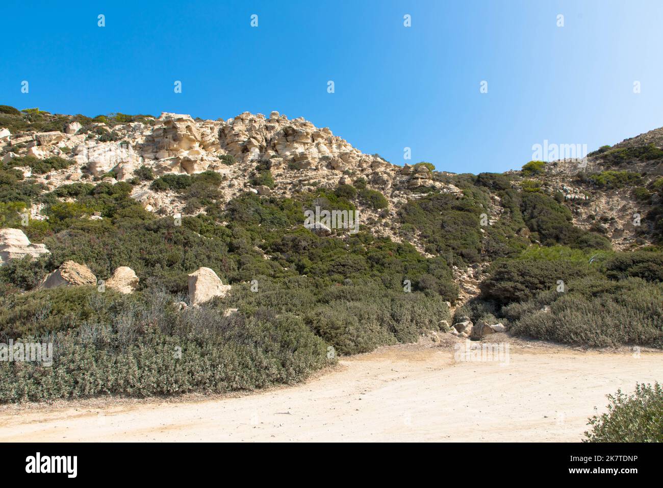Gravel road to the top of Attavyros mountain. Arid landscape and blue ...