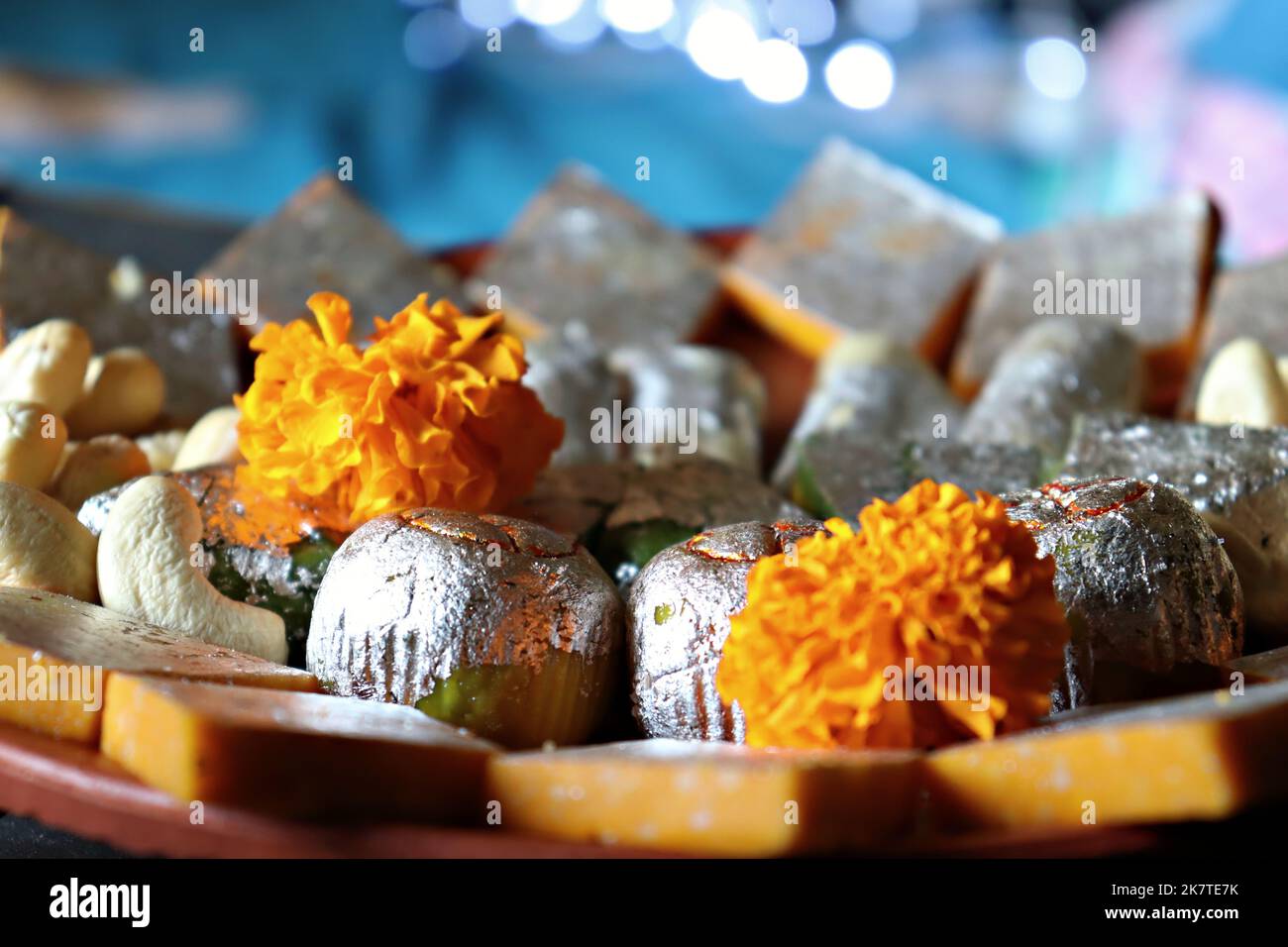 Assorted Indian sweets/dry fruits/marigold flower in a terracotta/clay ...
