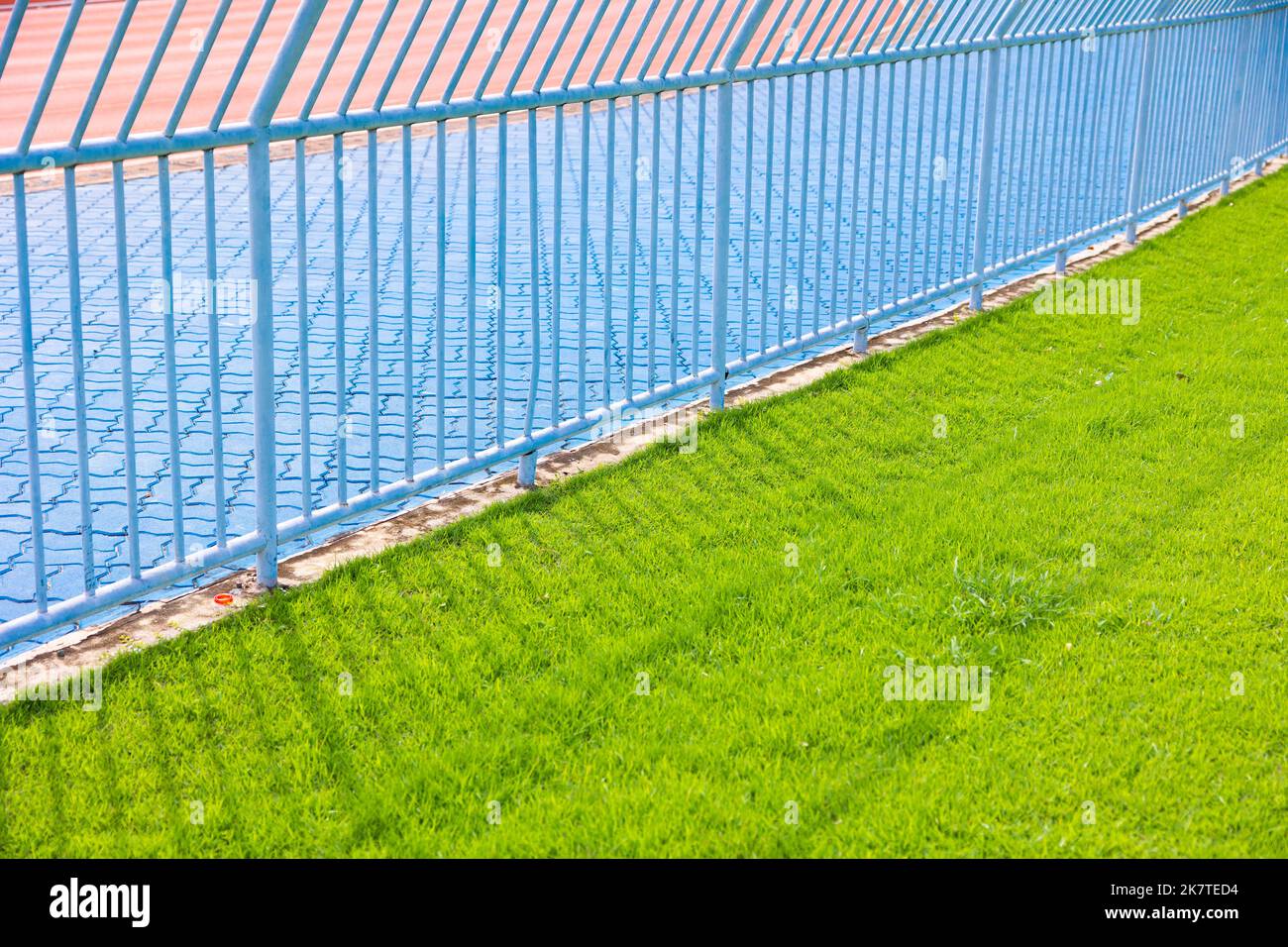 green grass around sport stadium aside running track with fence Stock ...