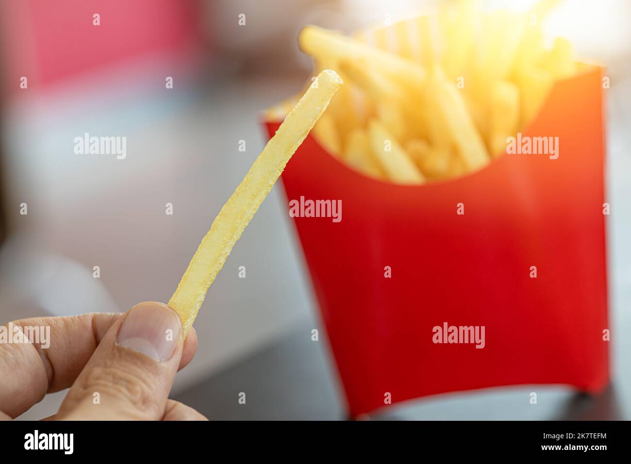 french fries. closeup male hand holding golden potato stick fry popular ...