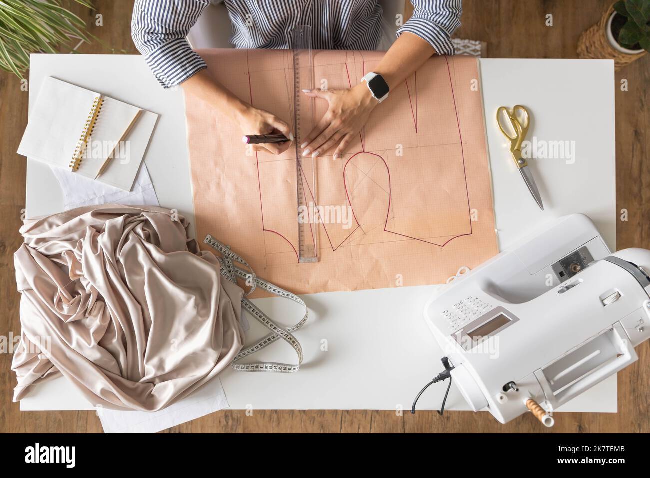 Female tailor hands draw sew pattern ruler on desk clothes creating ...