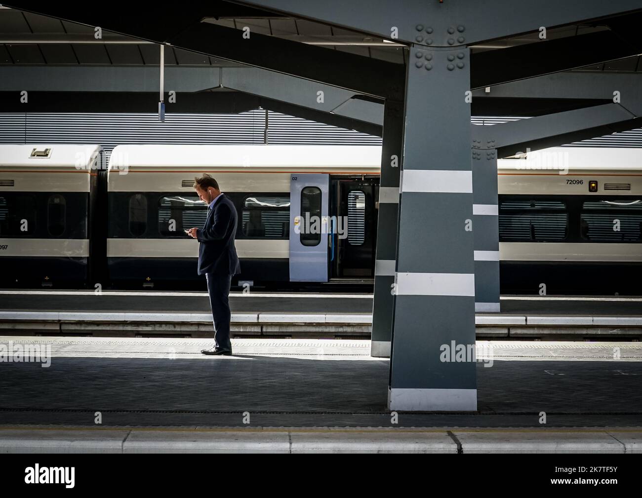Commuter at a station waiting for a train Stock Photo - Alamy