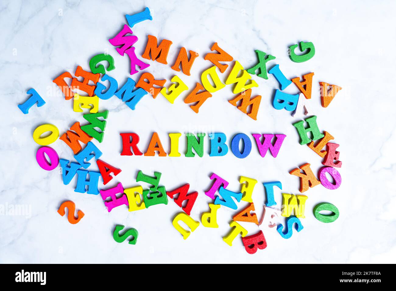 Group of colorful wooden letters scattered on gray with a RAINBOW word ...