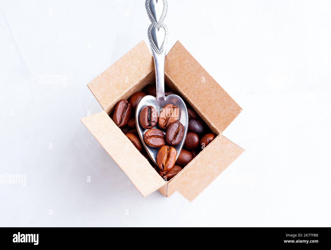 Teaspoon in a miniature shipping box full of roasted coffee beans ...