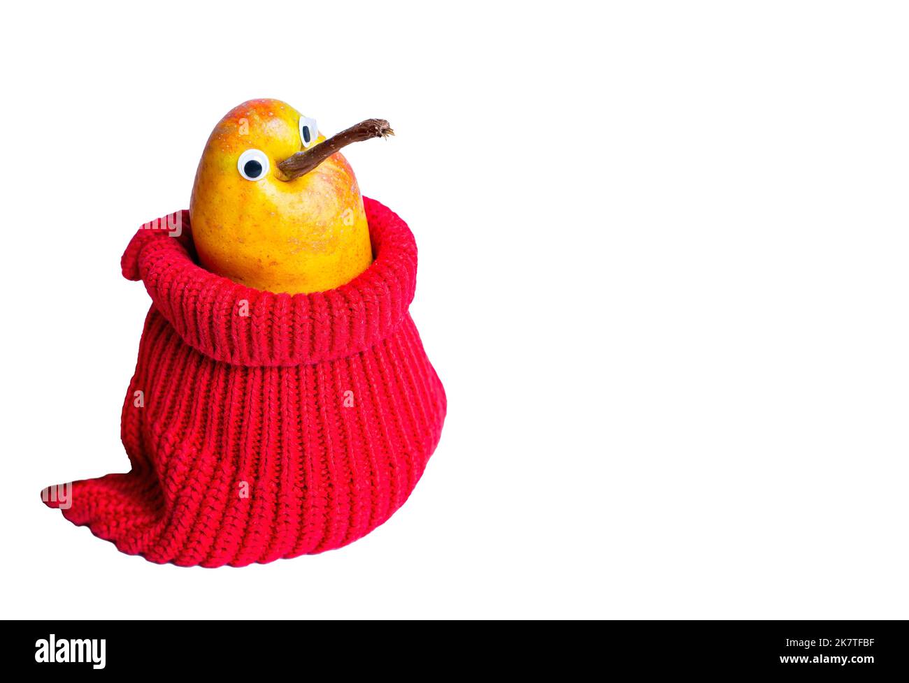 Close-up of a cute anthropomorphic pear with googly eyes placed in a ...