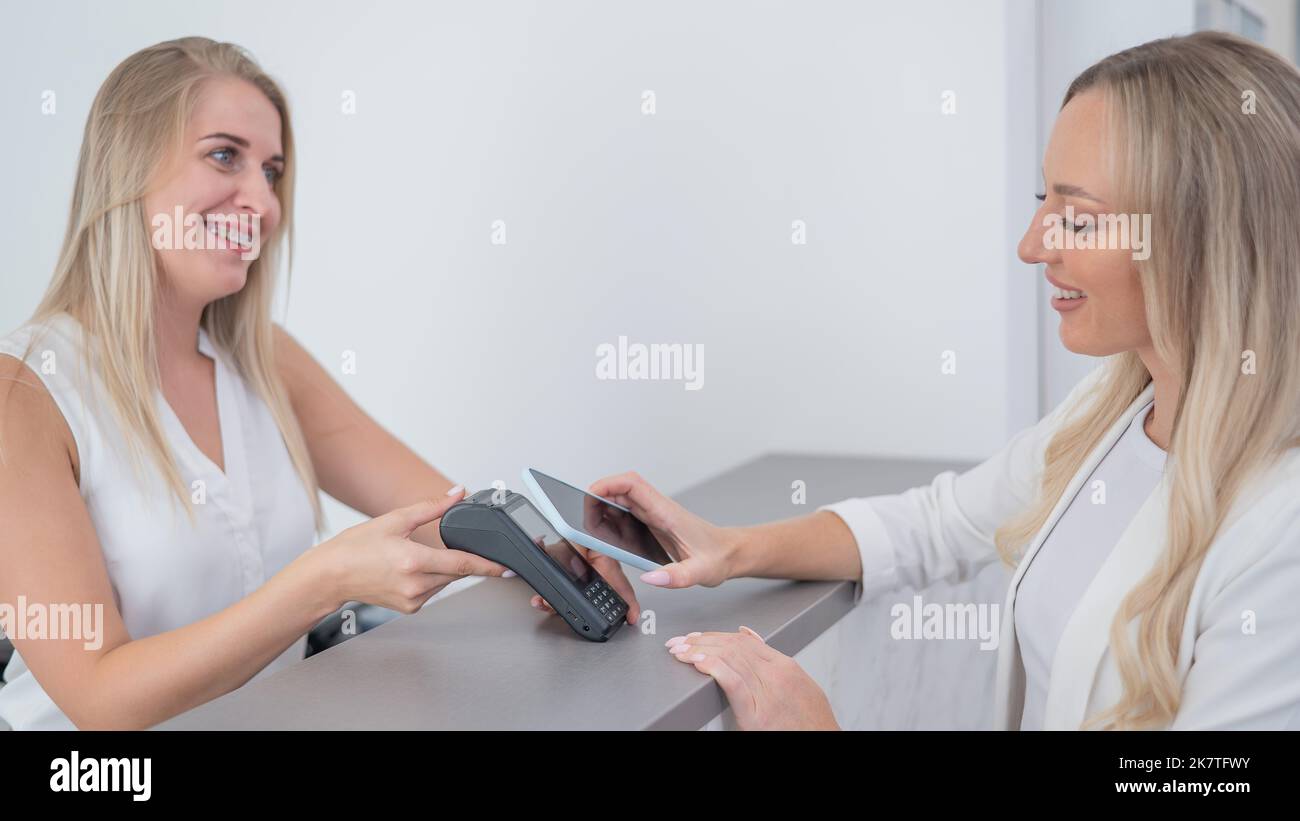A woman pays using a non -contact payment of the NFC used by a ...