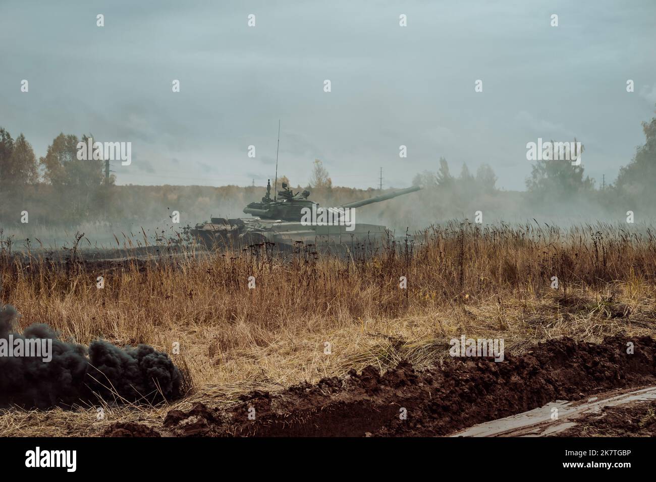 Heavy Military Tank on the battlefield at a hot spot. A tank moves ...