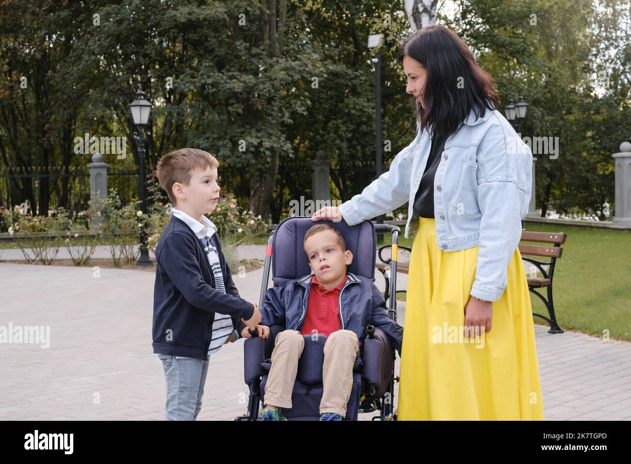 Family with child that has cerebral palsy, wheelchair user walking ...