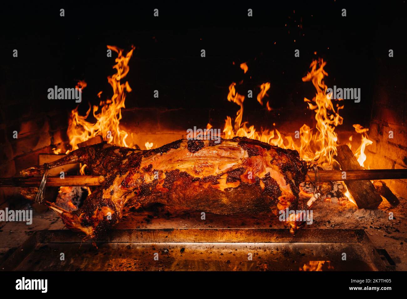 The lamb is cooked entirely on a spit on the fire. Cooking Stock Photo ...