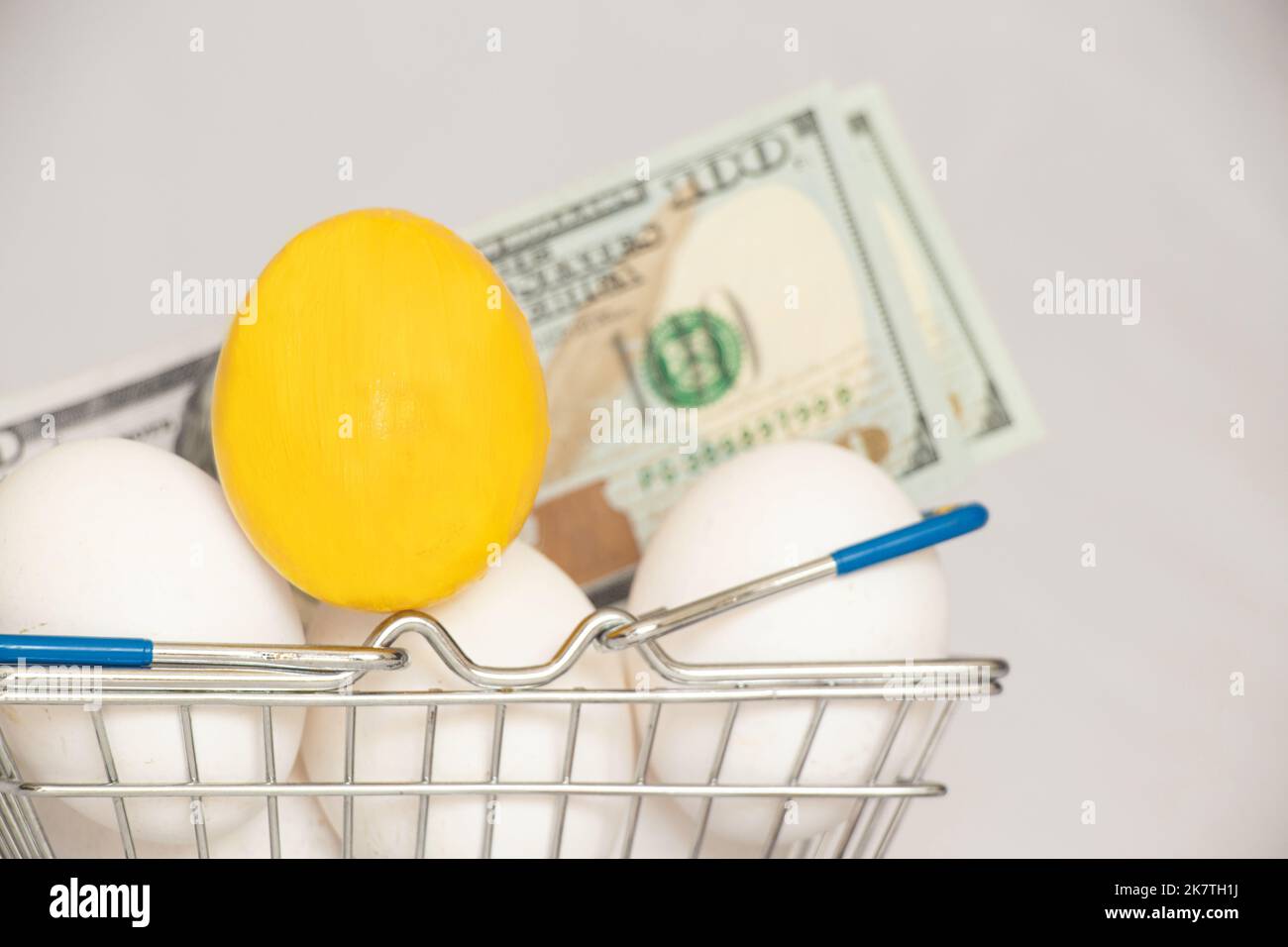 A golden chicken egg and white eggs lie in a basket from a supermarket ...
