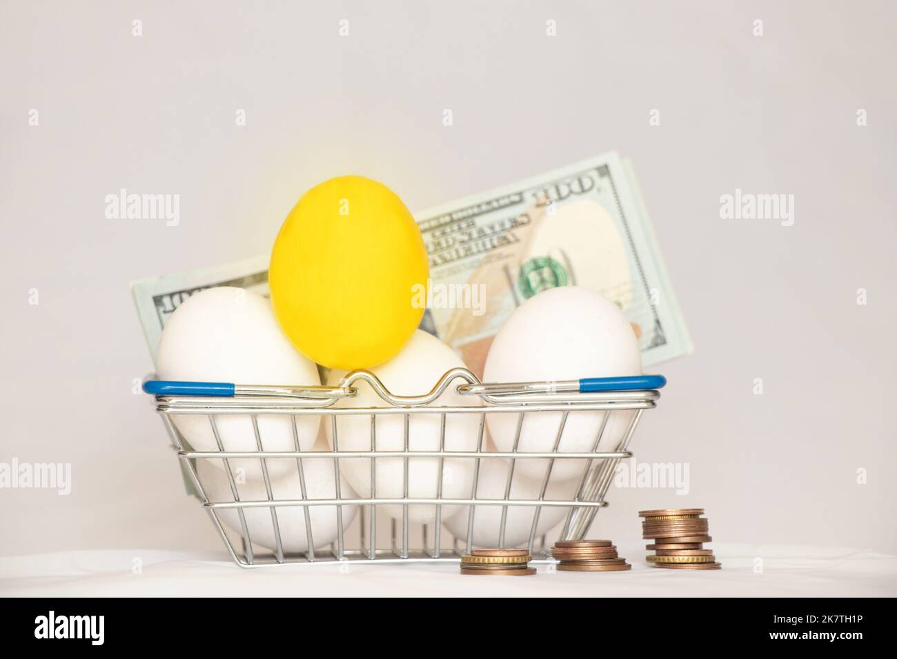 A golden chicken egg and white eggs lie in a basket from a supermarket ...