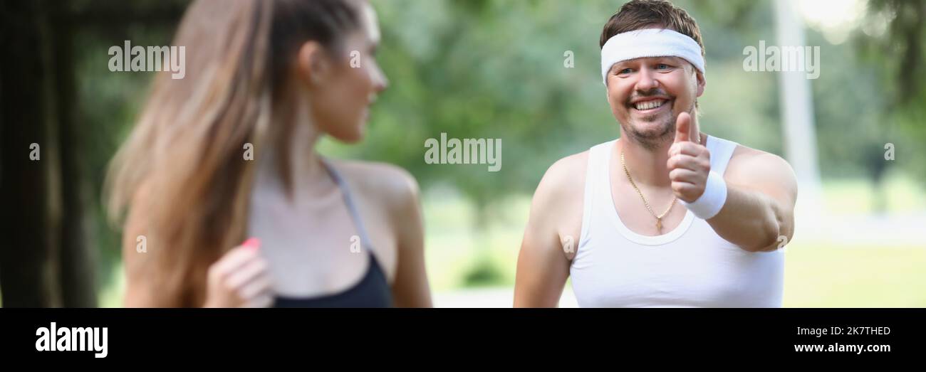 Tired middle aged man running in early morning with woman friend Stock ...