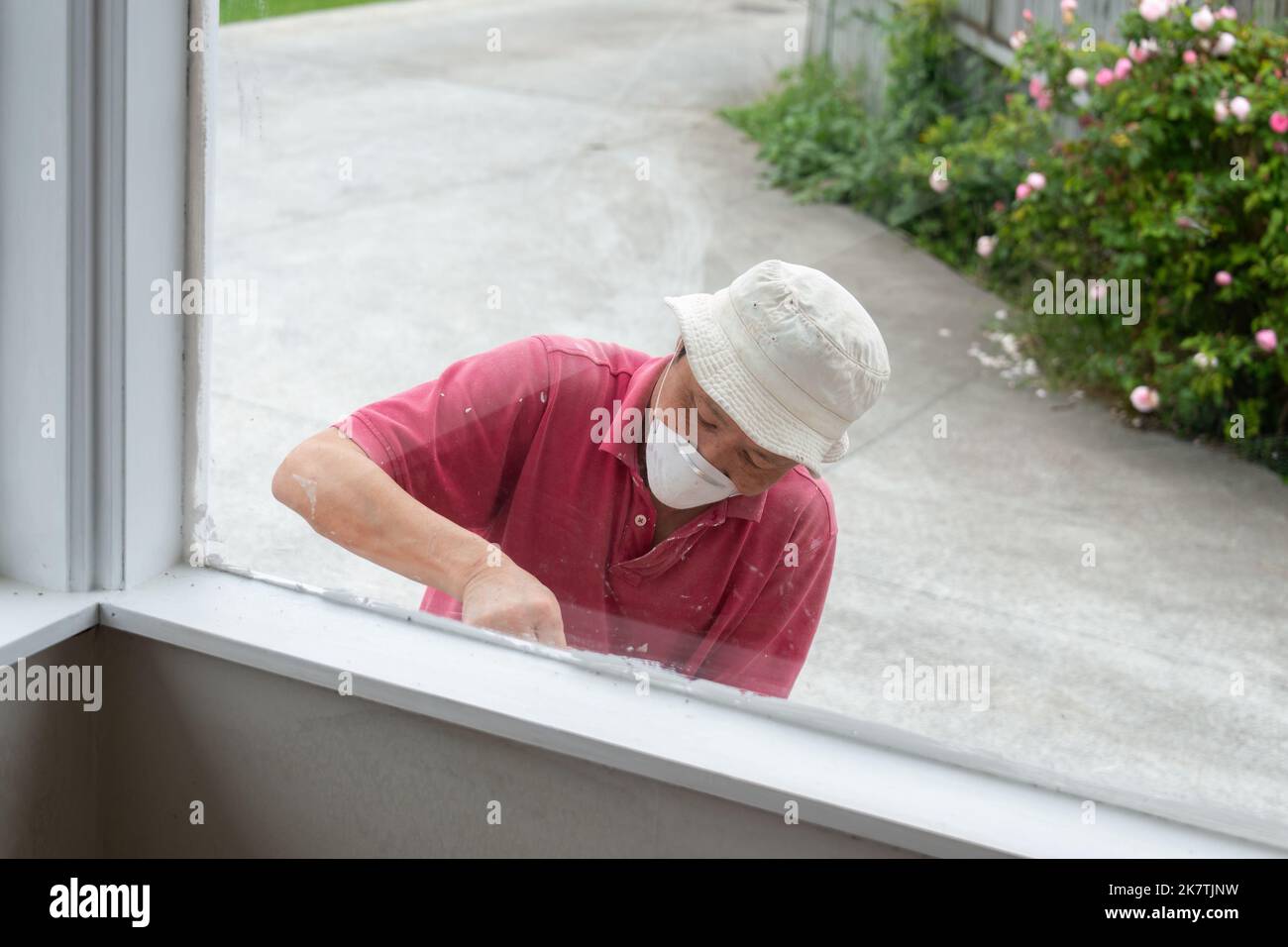 Man painting and cleaning window frame outside of the house. Home ...
