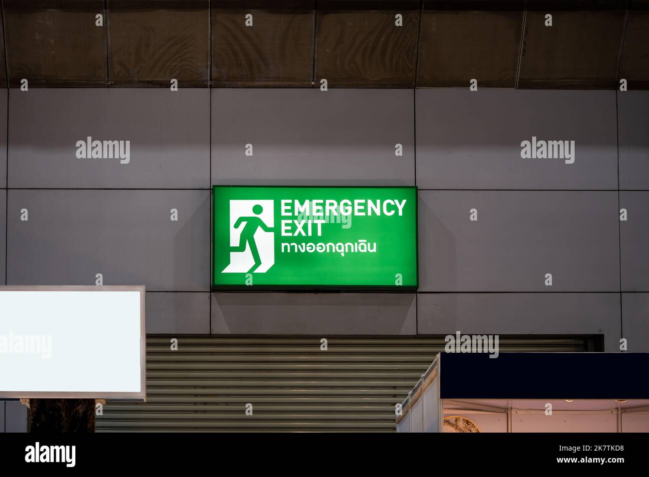 Large Emergency exit sign green light box is placed on the wall of ...