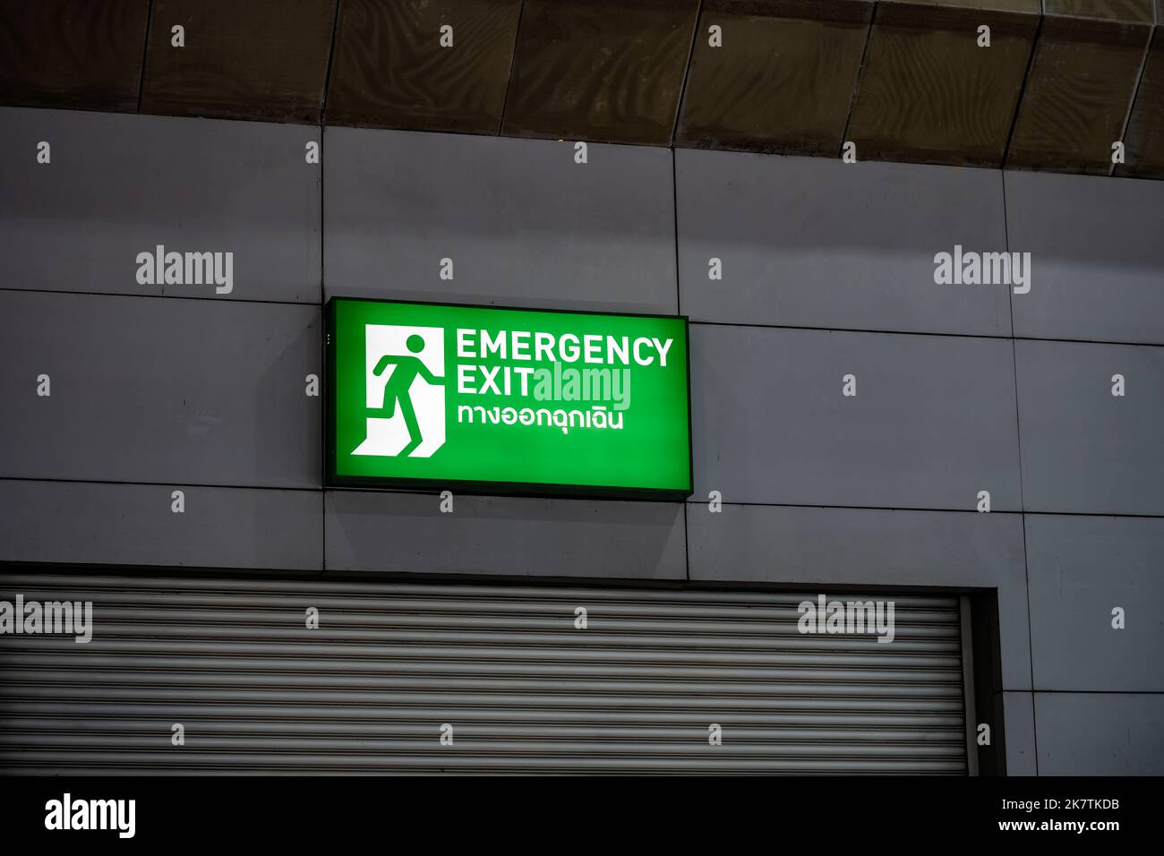 Large Emergency exit sign green light box is placed on the wall of ...