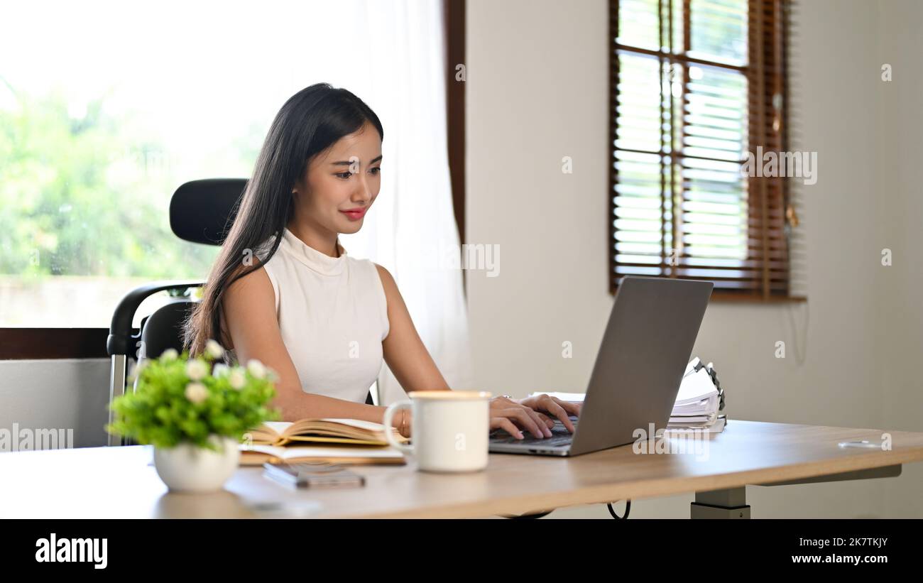 Successful and confident young Asian businesswoman or female manager ...