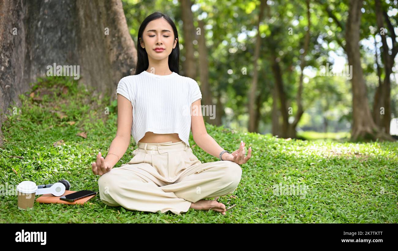 Peaceful and calm young Asian female in casual comfy clothes sitting in ...