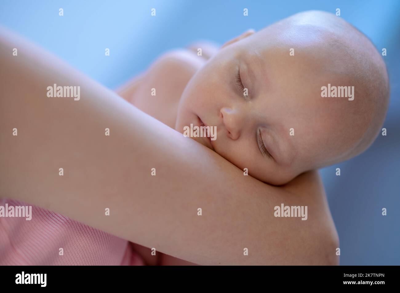 Caring female parent cradling her cute baby Stock Photo - Alamy