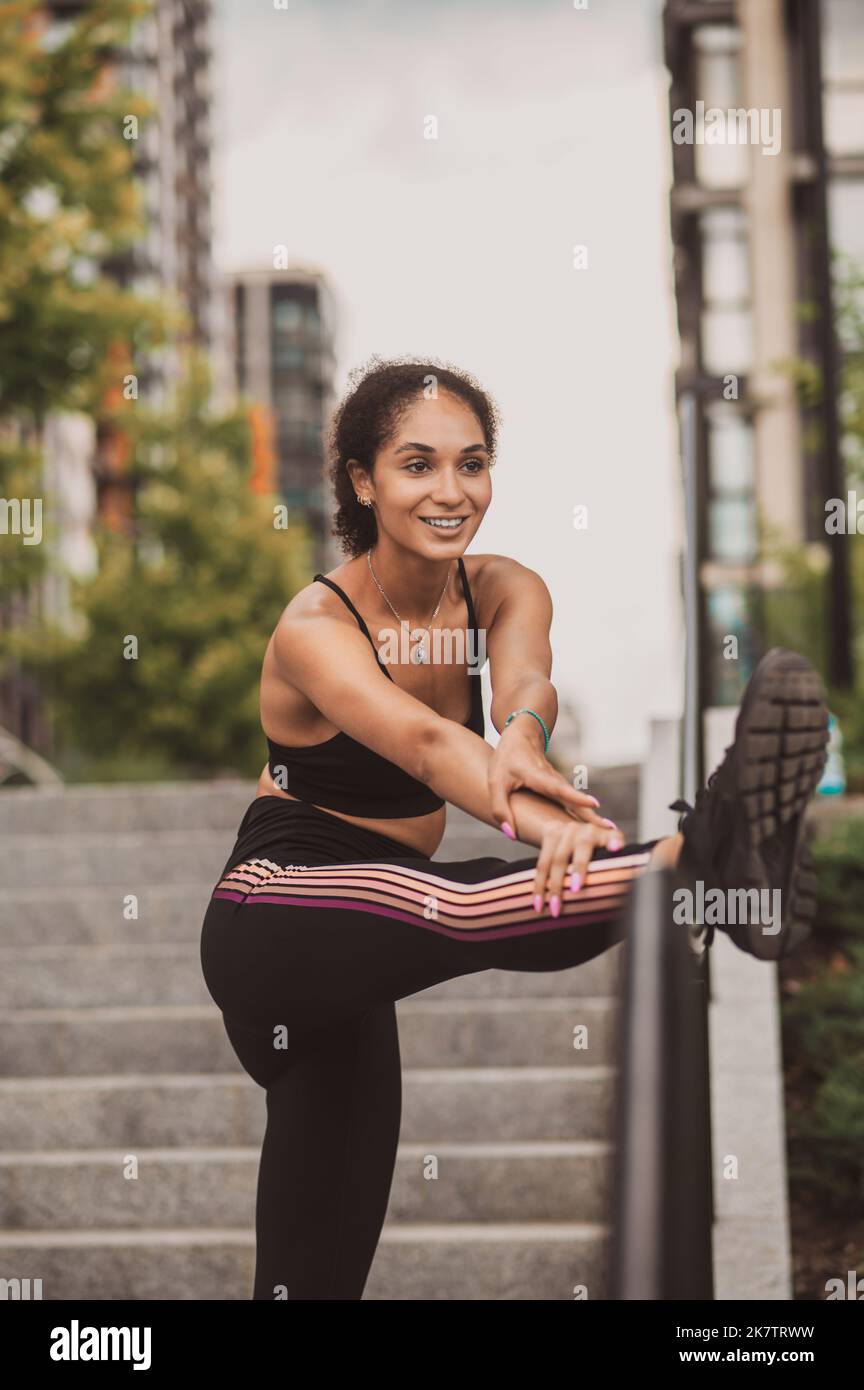 Cute dark-haired young girl exercising outside Stock Photo - Alamy
